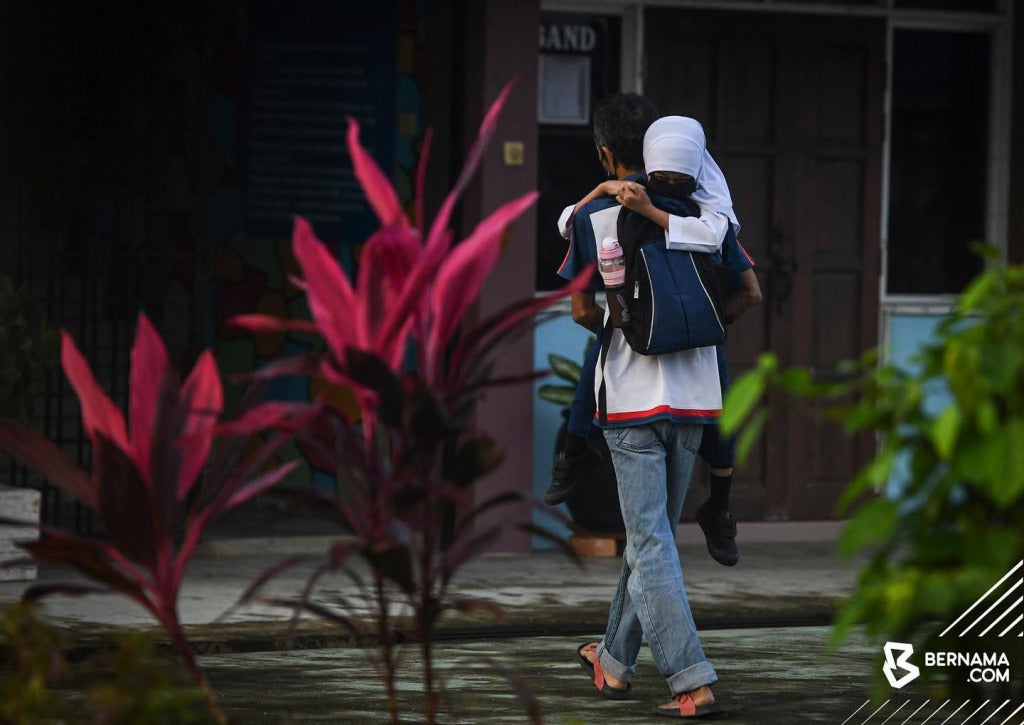 M'sians Praise T'ganu Dad Who Carried 11yo Daughter With Movement Disorder To School - WORLD OF BUZZ